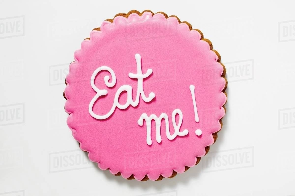 Biscuit with pink icing and the words 'Eat me!' - Stock Photo - Dissolve