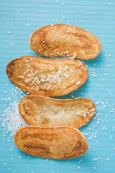 Four home-made potato crisps with salt - Stock Photo - Dissolve
