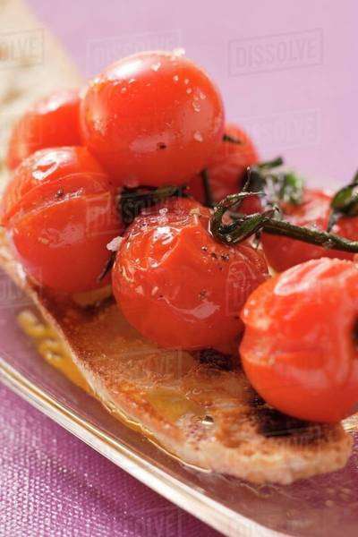 Stewed cherry tomatoes on white bread - Stock Photo - Dissolve