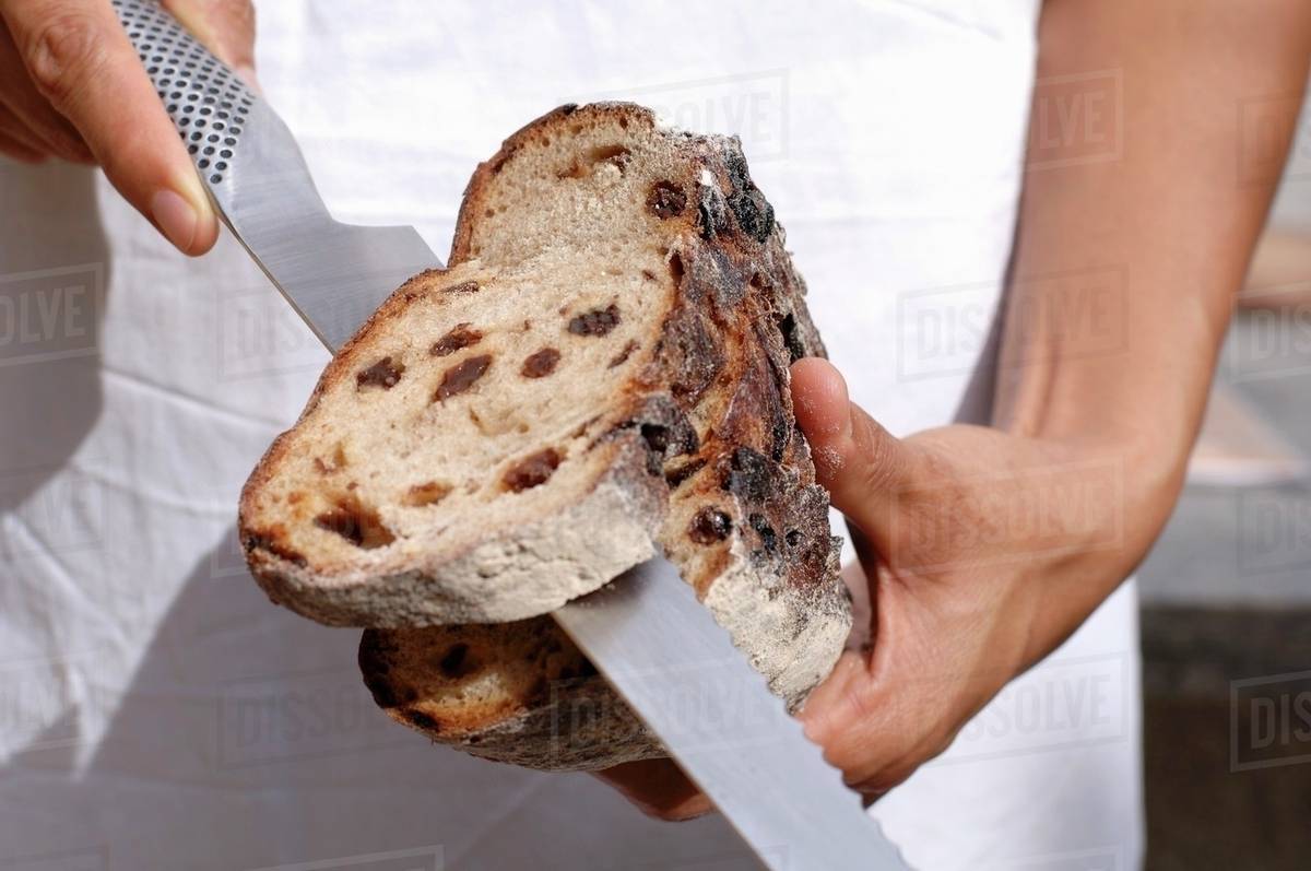 Cutting a slice of bread - Royalty-free Stock Photo | Dissolve
