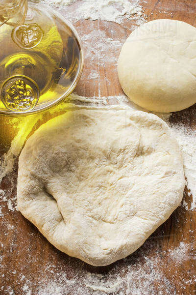 Uncooked dough, rolled out and in a ball, olive oil - Royalty-free ...