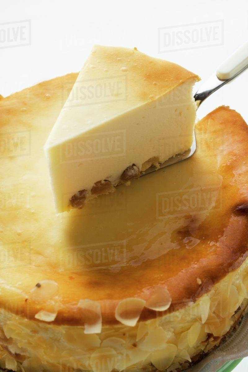 Cheesecake, a piece cut, with piece on server - Stock Photo - Dissolve