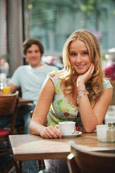Germany, Munich, Teenage Girl smiling with young man in background ...