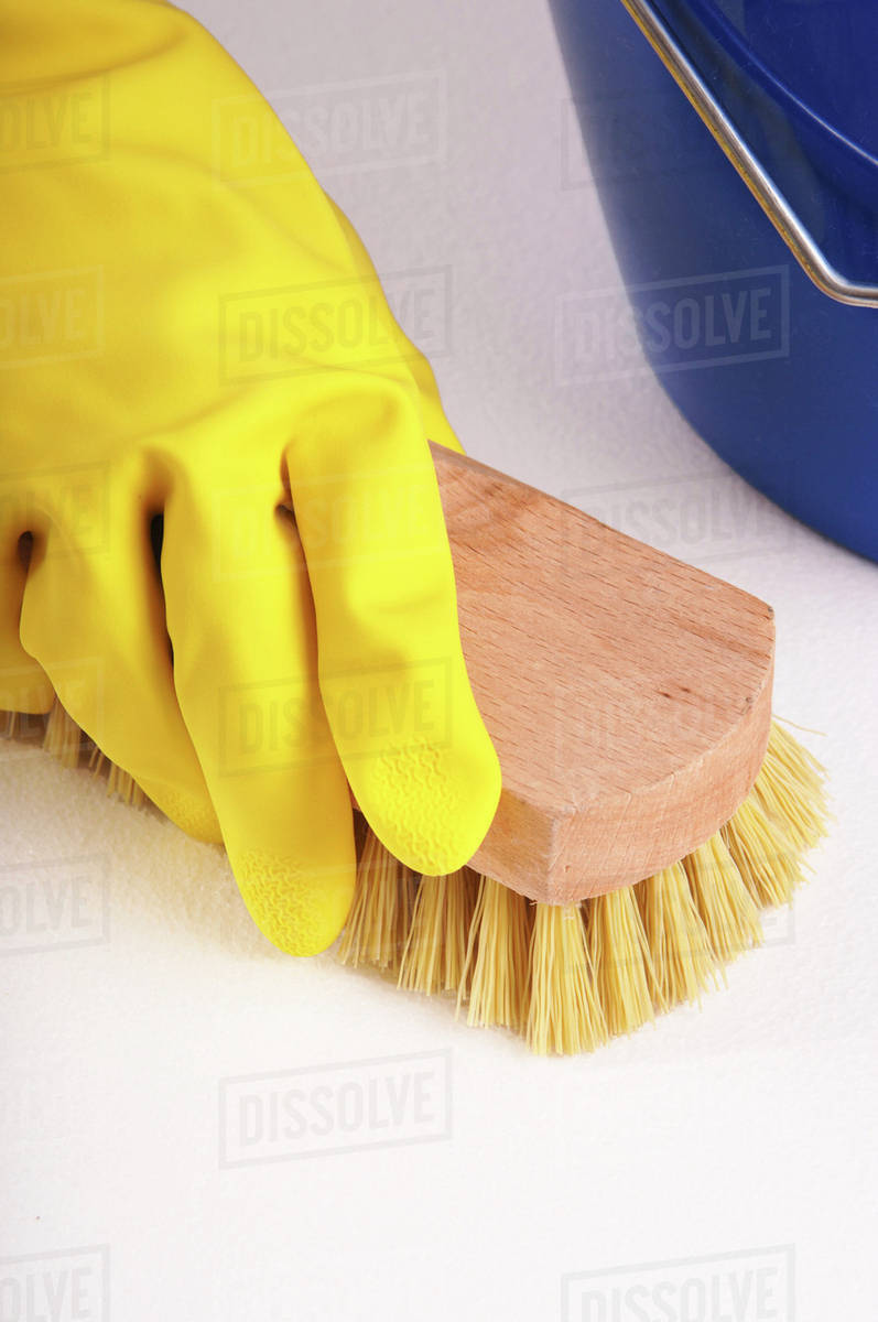 Person scrubbing surface, close-up - Stock Photo - Dissolve