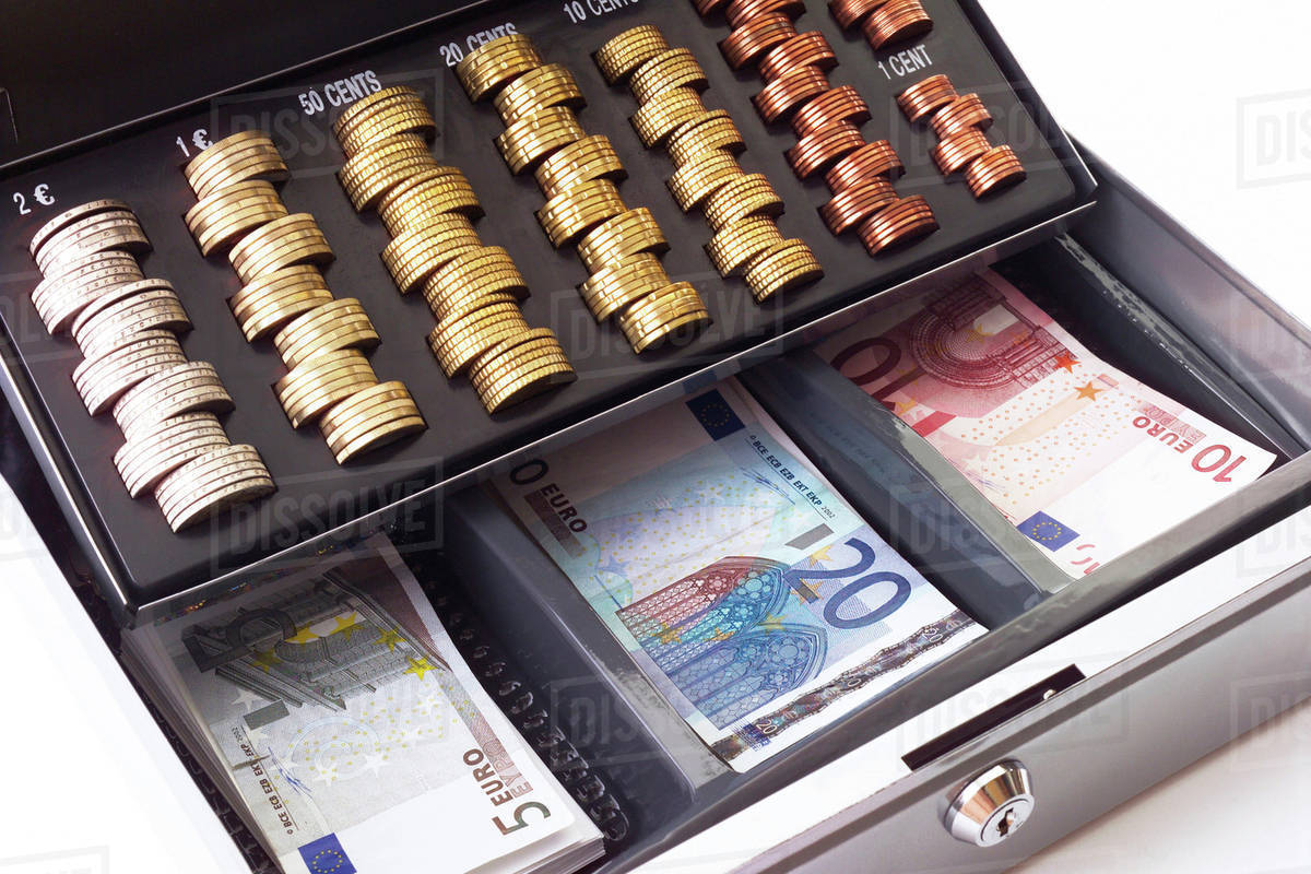Cash box filled with coins and banknotes, elevated view, close-up ...
