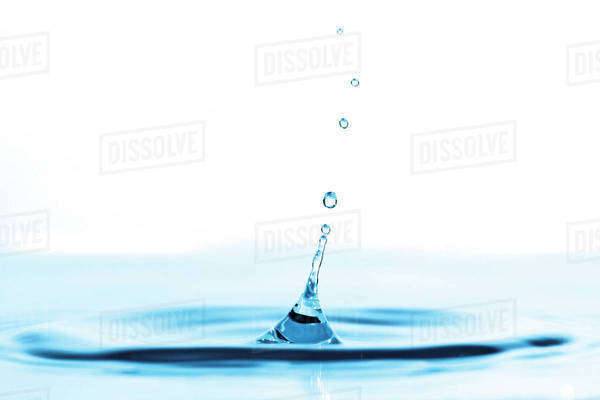Water drop falling into water, close-up - Stock Photo - Dissolve