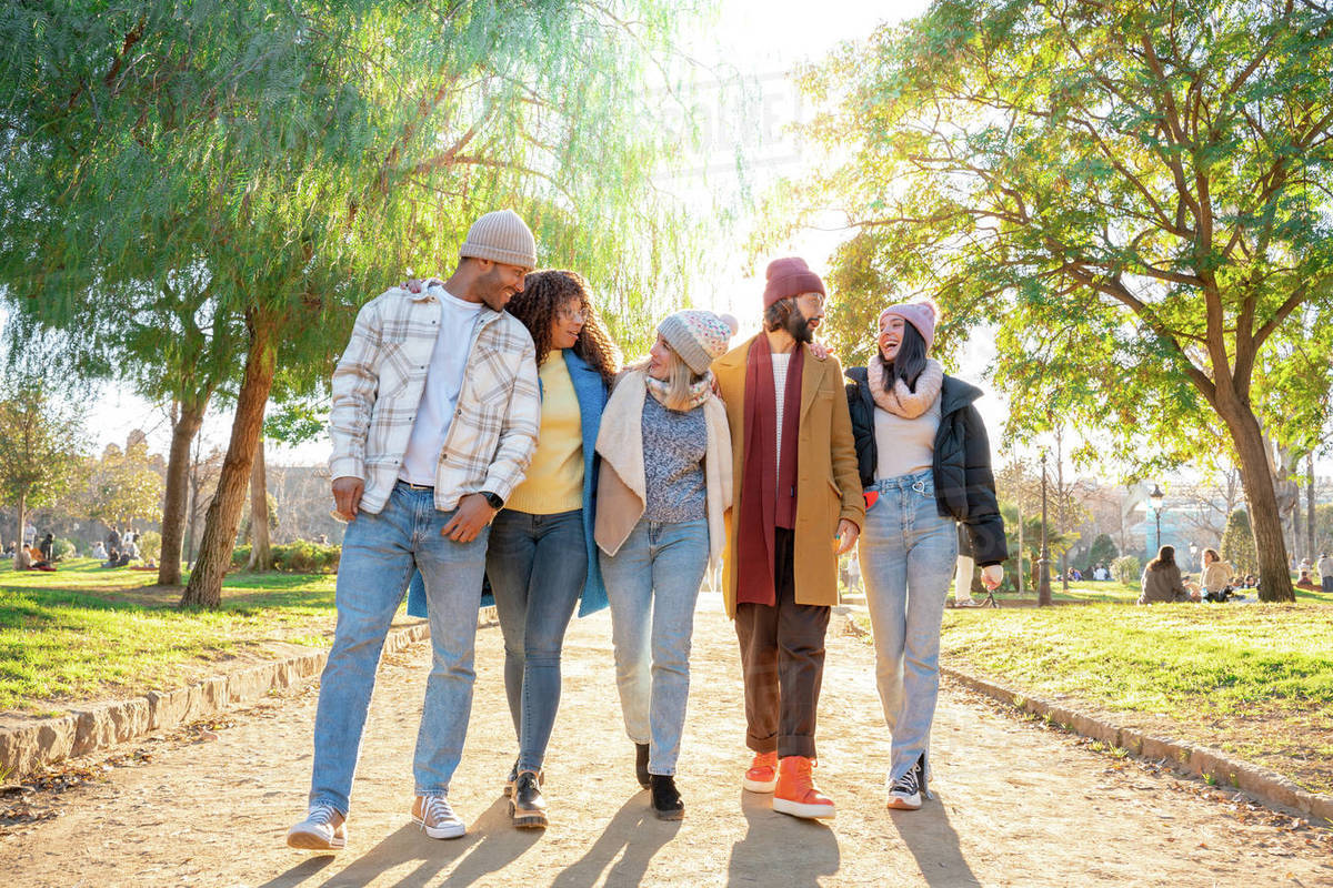 Cheerful group of friends walking outdoors in the park having fun ...