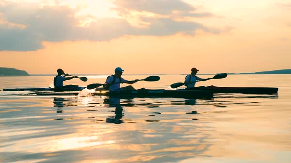 People are canoeing while the sun is setting at the lake - 4K Royalty ...