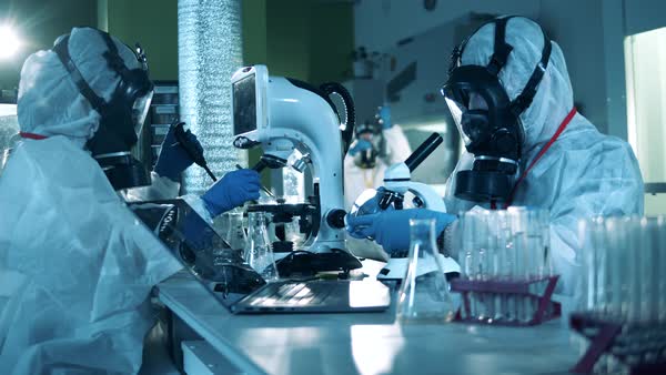 Researchers in hazmat suits are examining probes in the laboratory ...