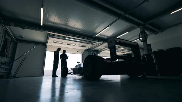 Garage with two men talking while observing a racing car - 4K Royalty ...