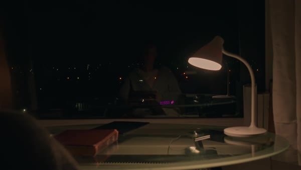 Lady reflection in big window woman sitting on the chair at the desk ...