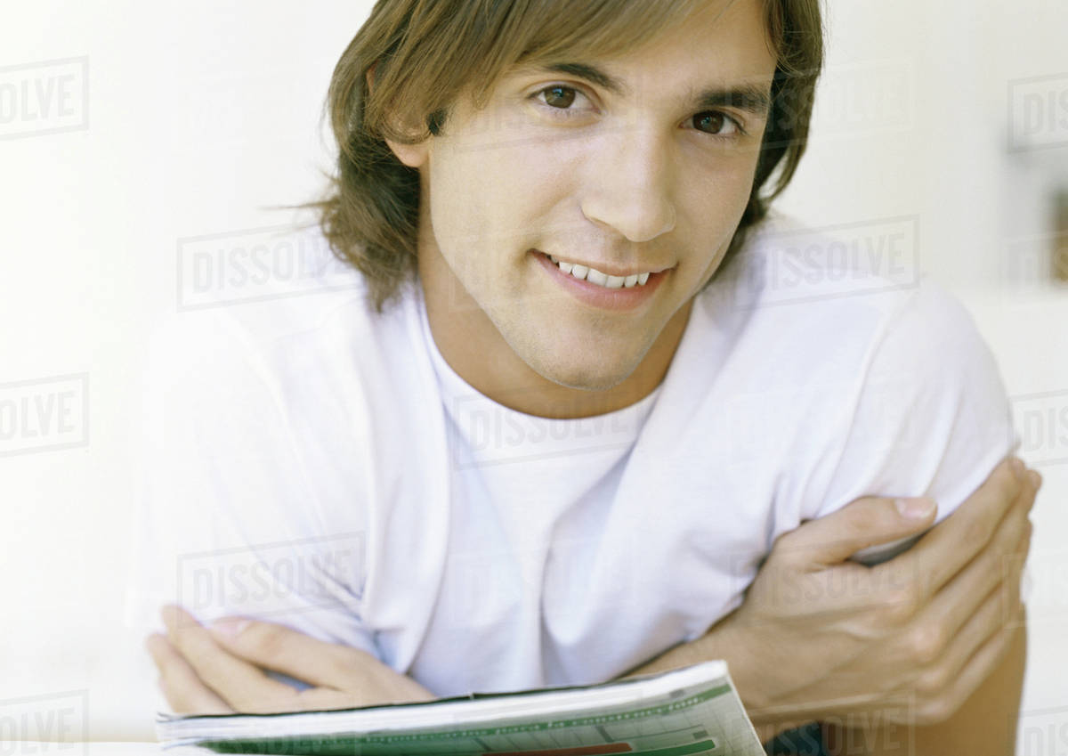 Man with magazine, smiling at camera - Royalty-free Stock Photo | Dissolve