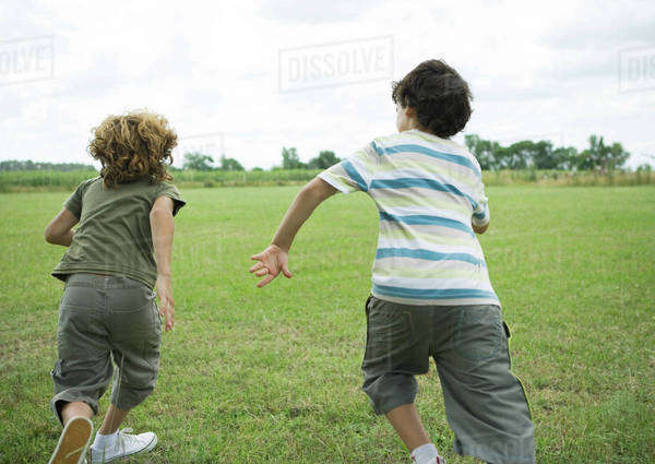 Boys running, rear view - Stock Photo - Dissolve