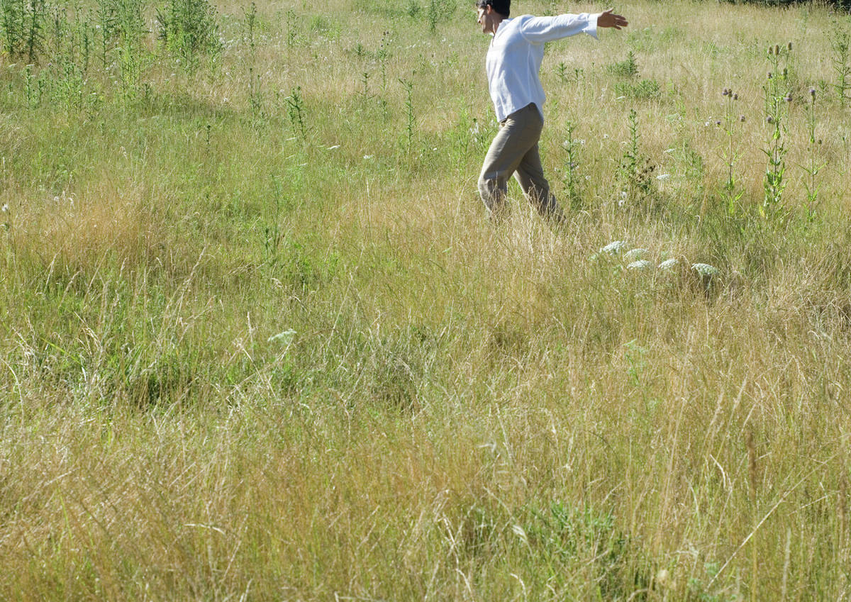 Man walking in field - Royalty-free Stock Photo | Dissolve