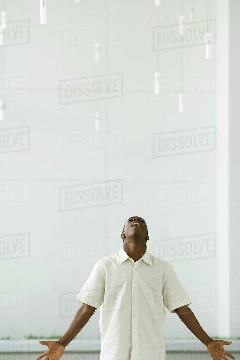 Teenage boy standing with head back, arms out, front view - Royalty ...