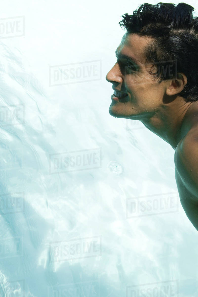 Man leaning over swimming pool, smiling, side view - Royalty-free Stock ...