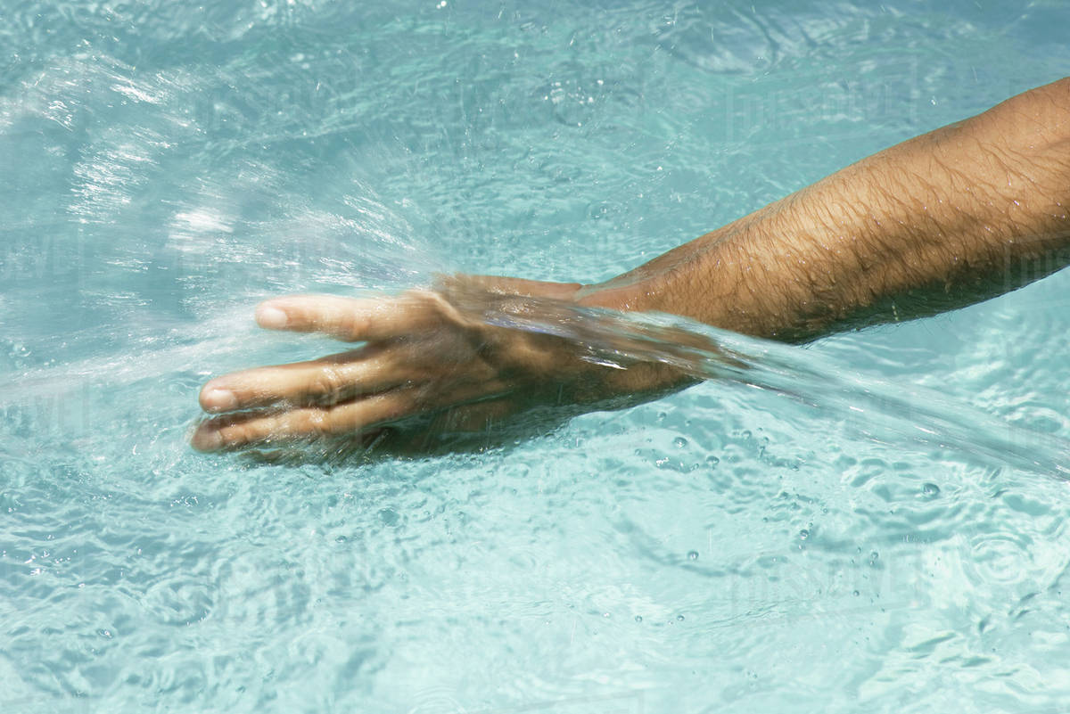 Man splashing in swimming pool, cropped view of arm - Royalty-free ...