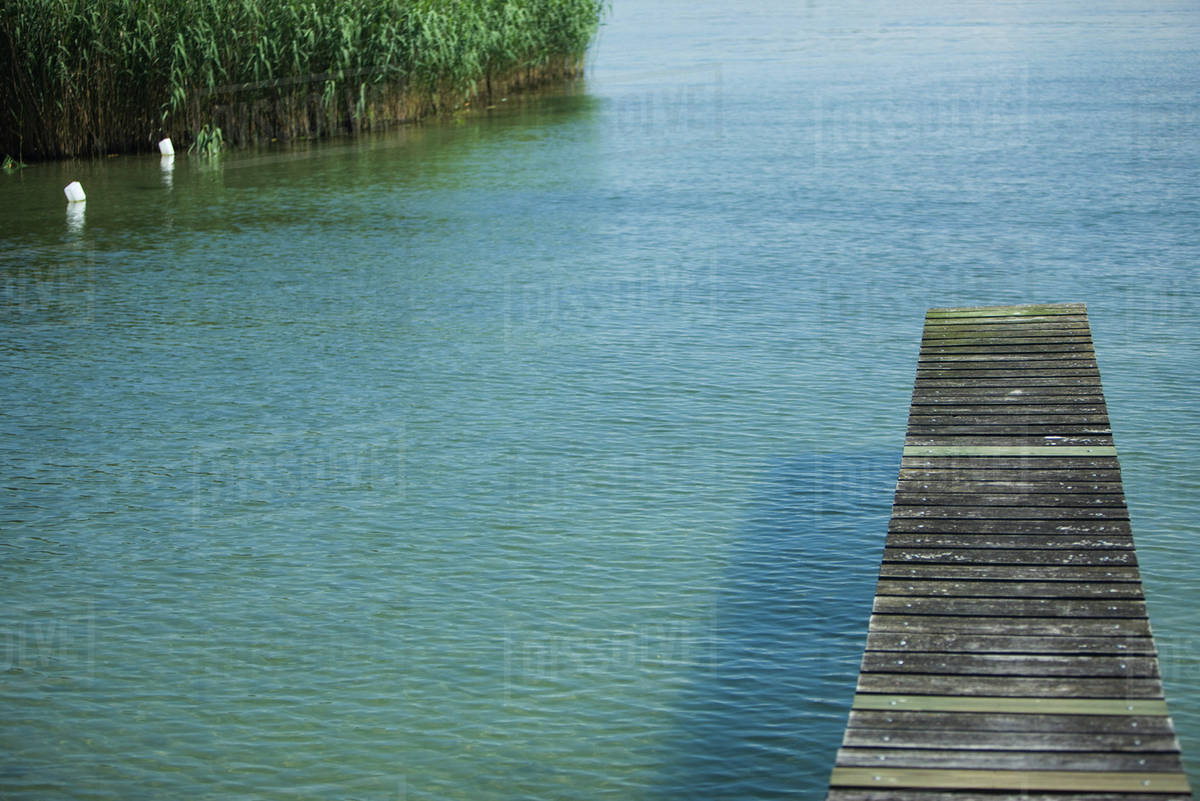 Pier over water, embankment in background - Stock Photo - Dissolve