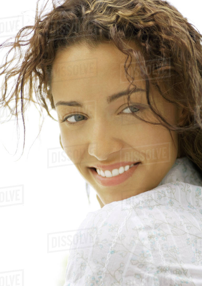Woman looking over shoulder, smiling, close-up - Royalty-free Stock ...