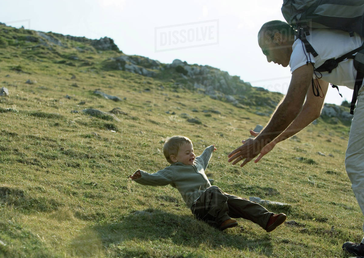 Boy falling as father reaches for him - Stock Photo - Dissolve