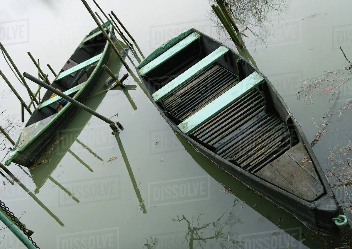 Rowboats floating in water, tilt - Stock Photo - Dissolve