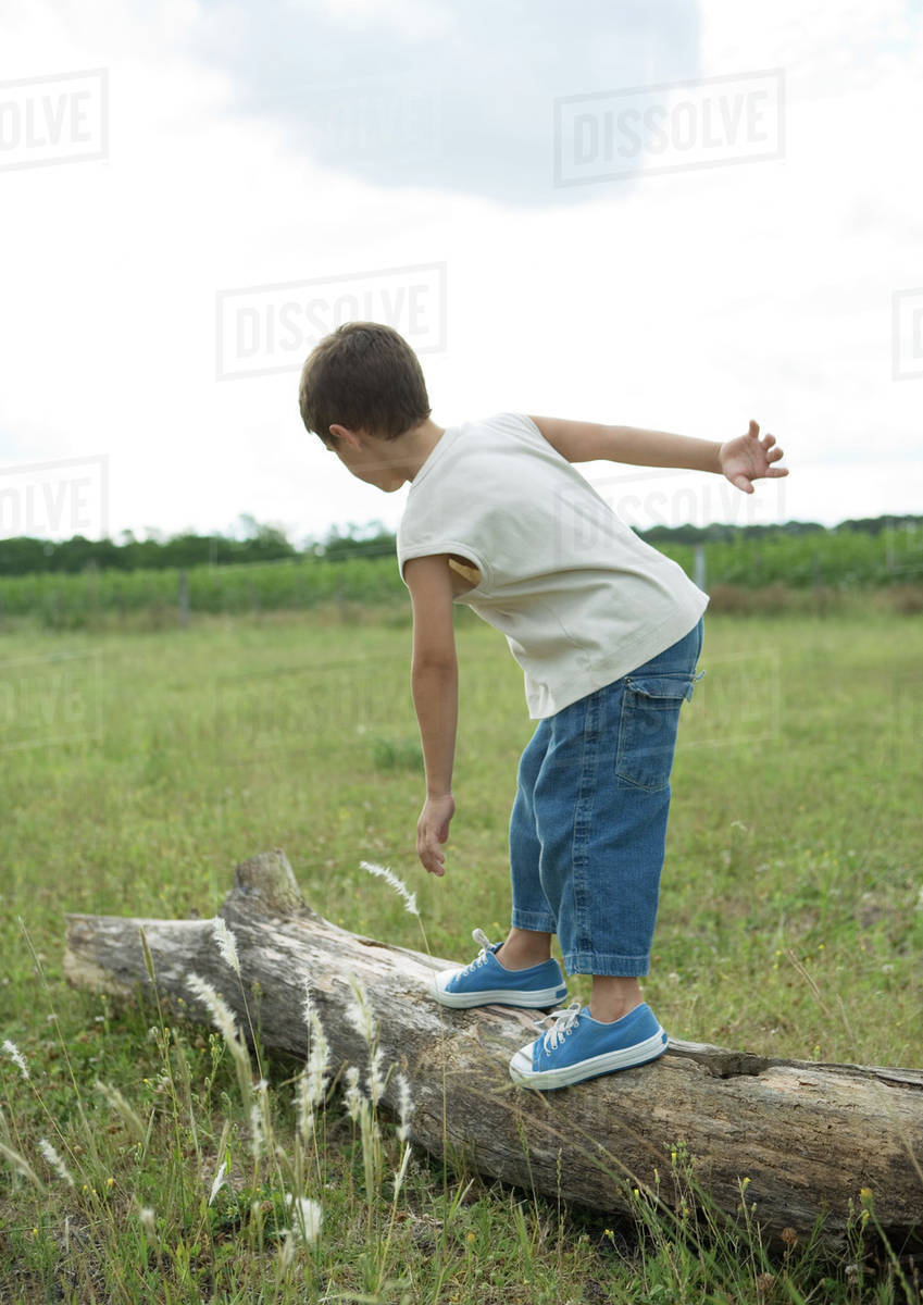 Boy standing on log - Royalty-free Stock Photo | Dissolve