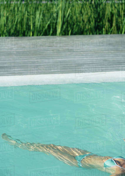 Woman floating on back in pool, neck down, high angle view - Stock ...