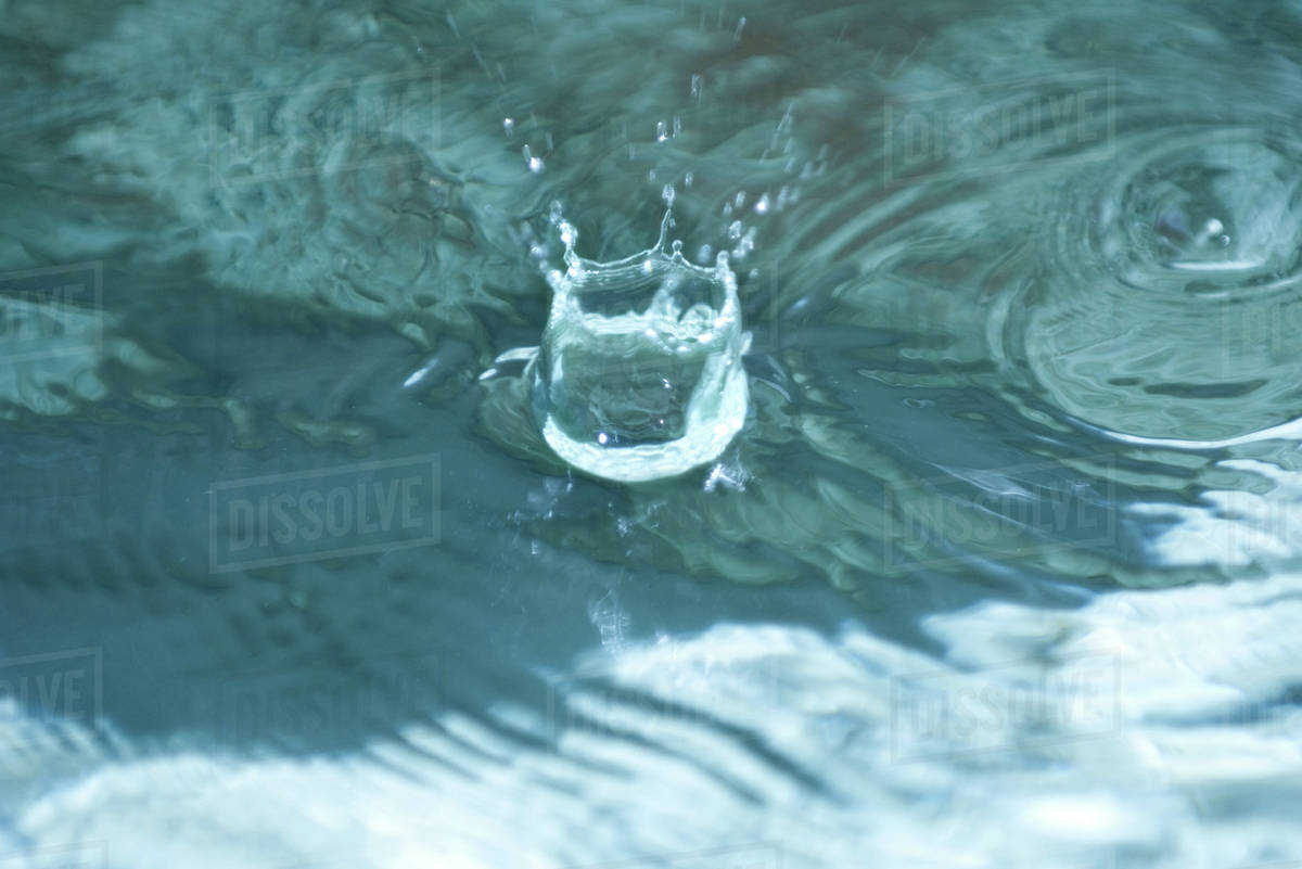 Drop of water hitting surface of water - Stock Photo - Dissolve