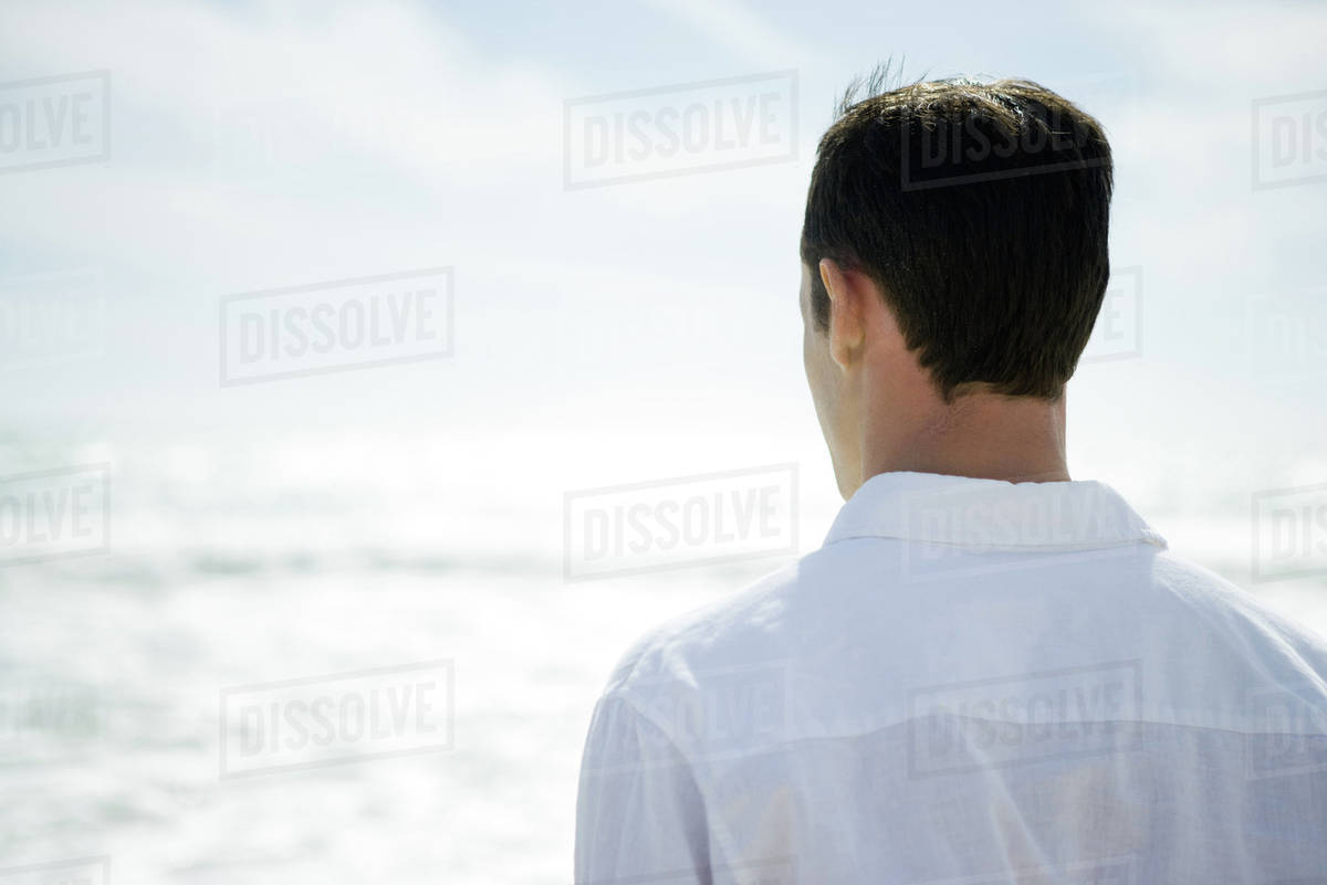Man looking at ocean, rear view - Royalty-free Stock Photo | Dissolve