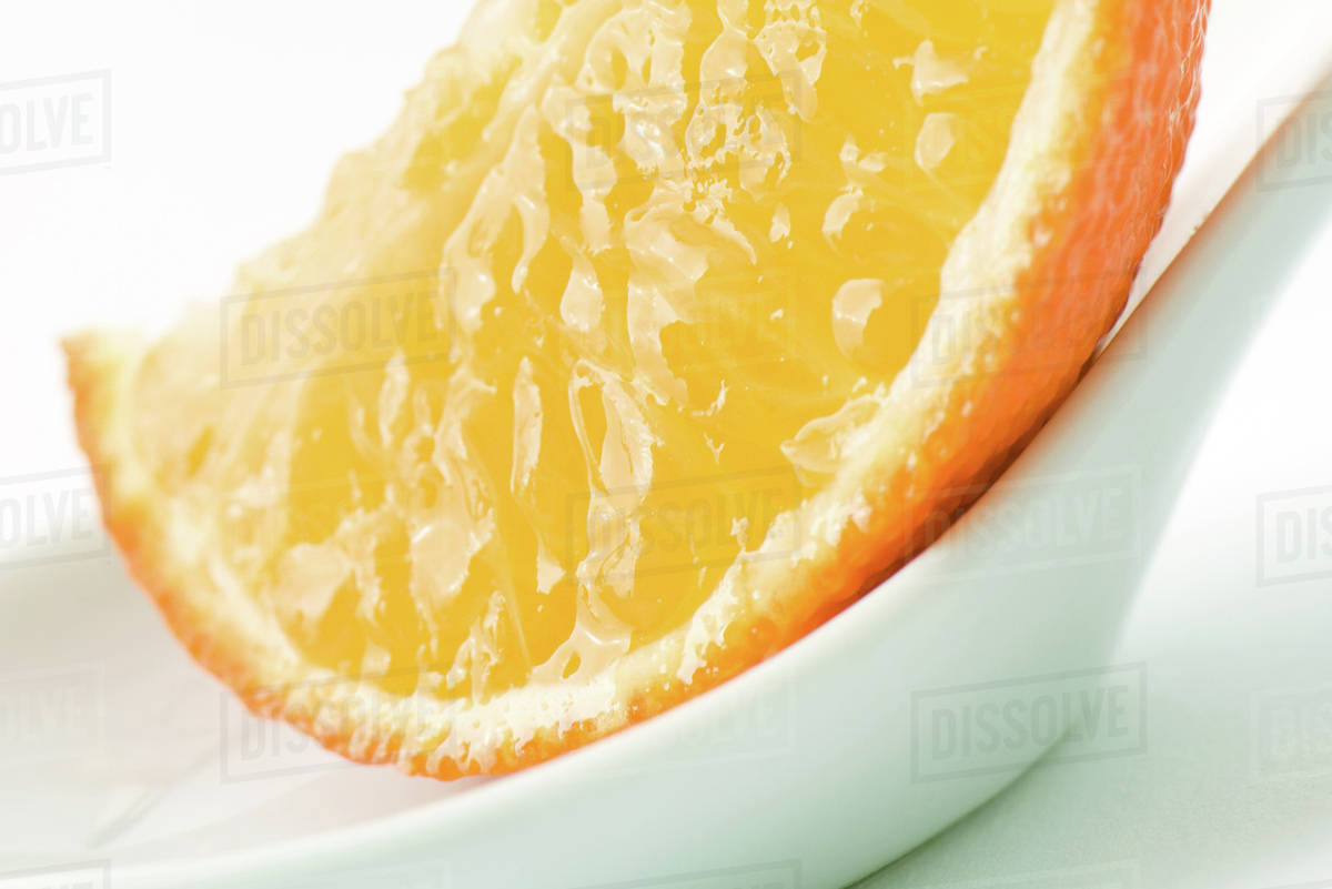 Orange slice in small dish, close-up - Royalty-free Stock Photo | Dissolve