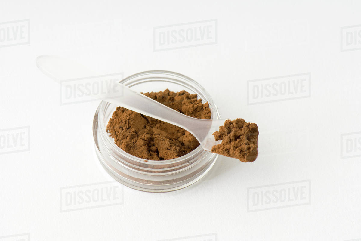 Cocoa powder in small cosmetic container - Stock Photo - Dissolve