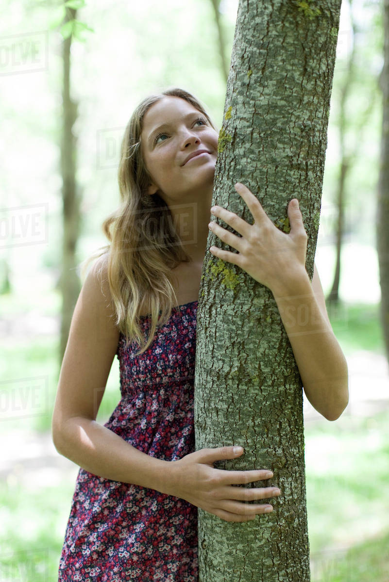 Young woman hugging tree - Stock Photo - Dissolve