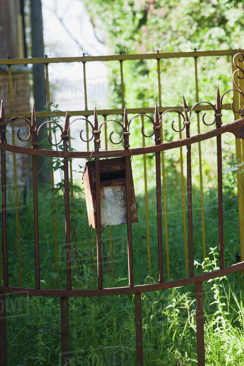 Mailbox hanging on wrought iron fence - Royalty-free Stock Photo | Dissolve