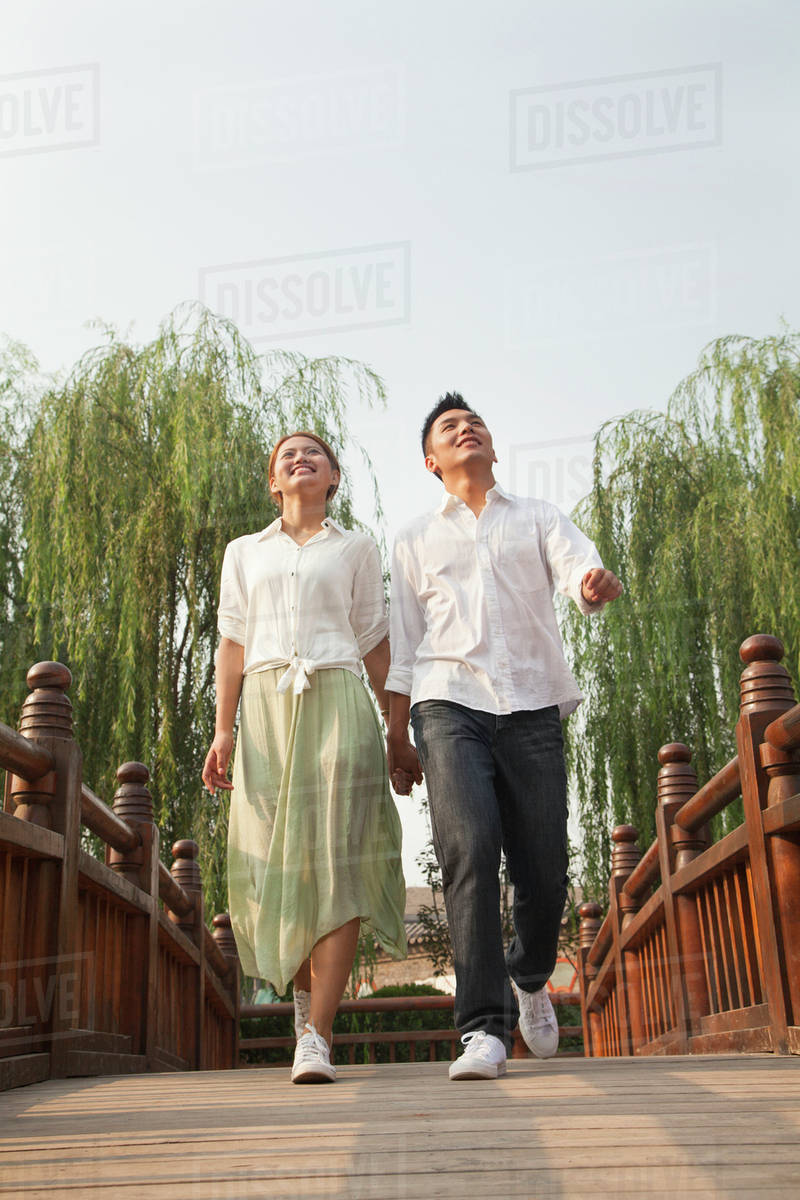 Young Couple Holding Hands and Crossing a Bridge - Royalty-free Stock ...