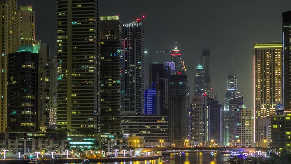 Promenade in Dubai Marina timelapse at night, UAE. Top view with palms ...
