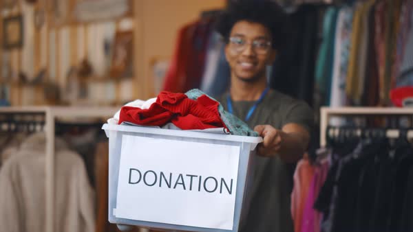African american guy holding donation box and looking at camera posing ...