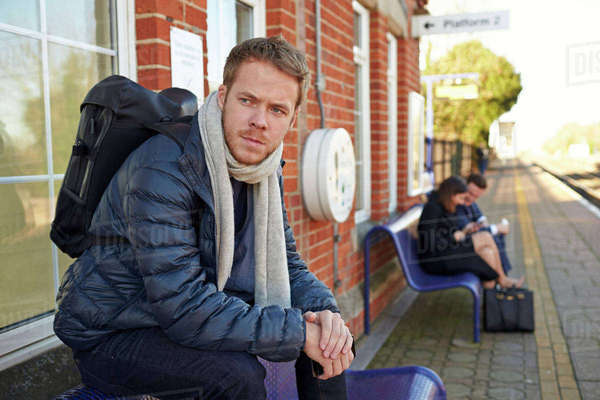 Man sitting on seat at railway station waiting for train - Stock Photo ...
