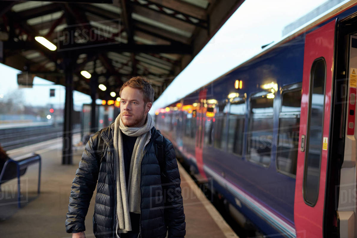 Man standing on railway platform waiting to board train - Royalty-free ...
