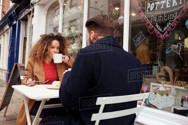 Couple sitting outside cafe enjoying coffee and snack - Royalty-free ...