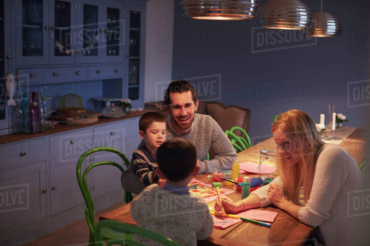 Family sitting at kitchen table and painting picture - Stock Photo ...