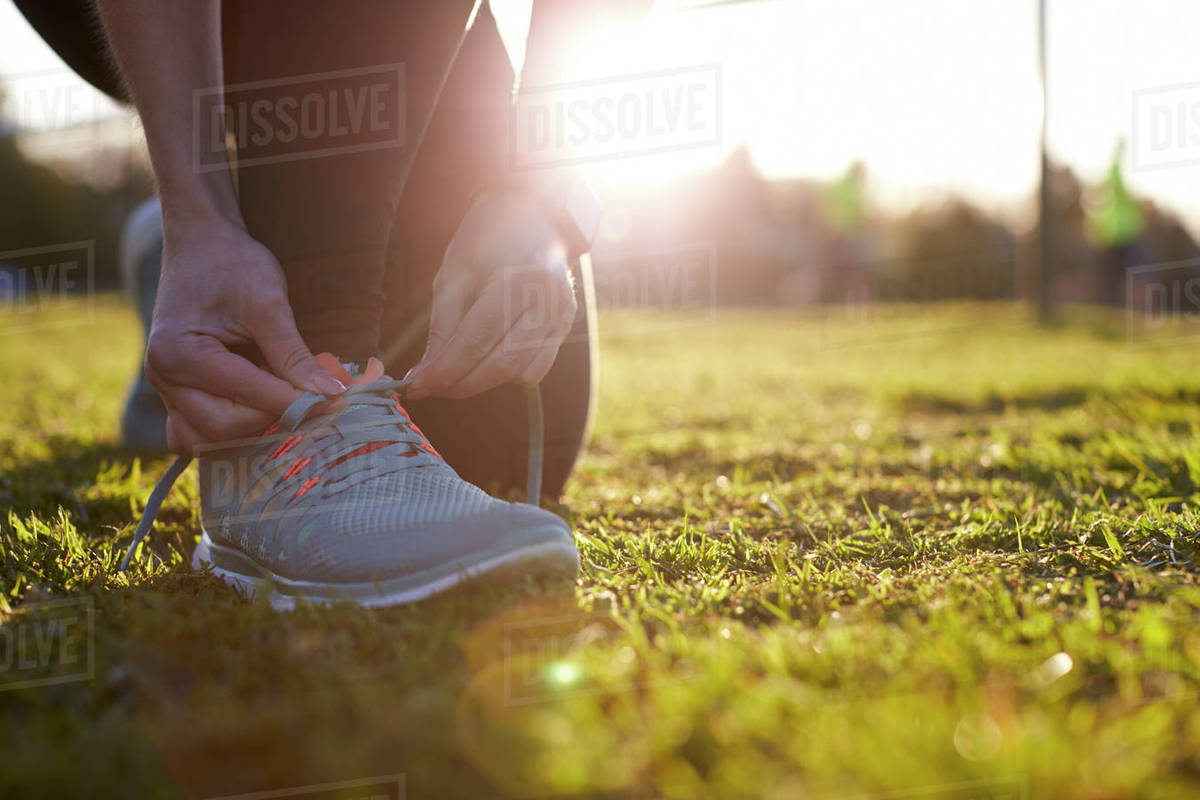 Close Up Of Woman Lacing Trainers Before Outdoor Exercise - Royalty ...