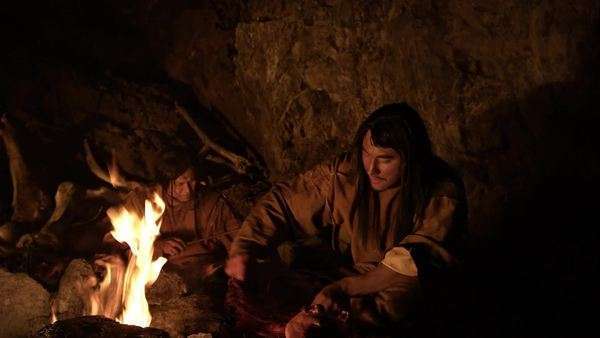 Montage of Native American family sitting around a campfire in a cave ...