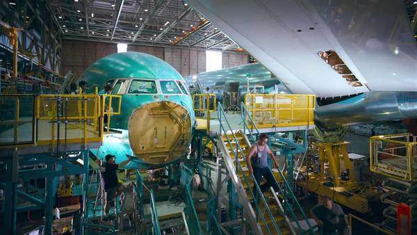 Push-in shot of engineers building an airplane. Originally sourced from ...