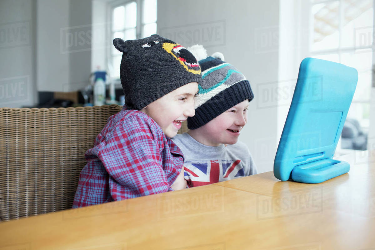 Brothers using computer at home - Royalty-free Stock Photo | Dissolve