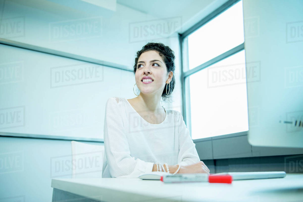 A professional woman sitting in front of a computer in an office ...