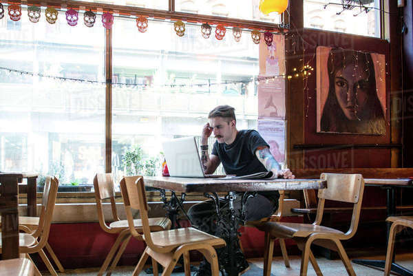 A young man sitting at a table in a coffee shop in Manchester - Royalty ...