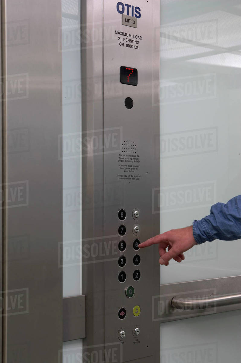 Man pressing lift buttons, UK office interior. - Royalty-free Stock ...