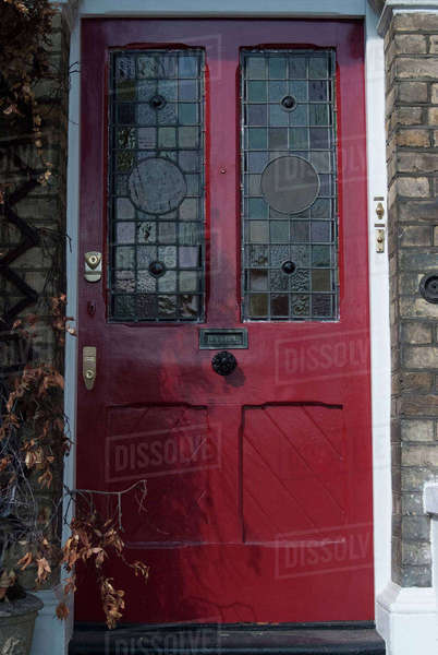 A red front door with a stained glass pattern - Stock Photo - Dissolve