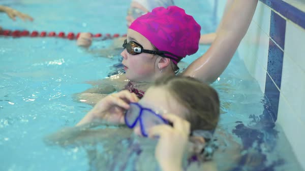Portrait of young sportive school girl in swimming pool during training ...