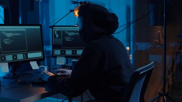 Hacker in mask wearing glasses trying to access system after being ...